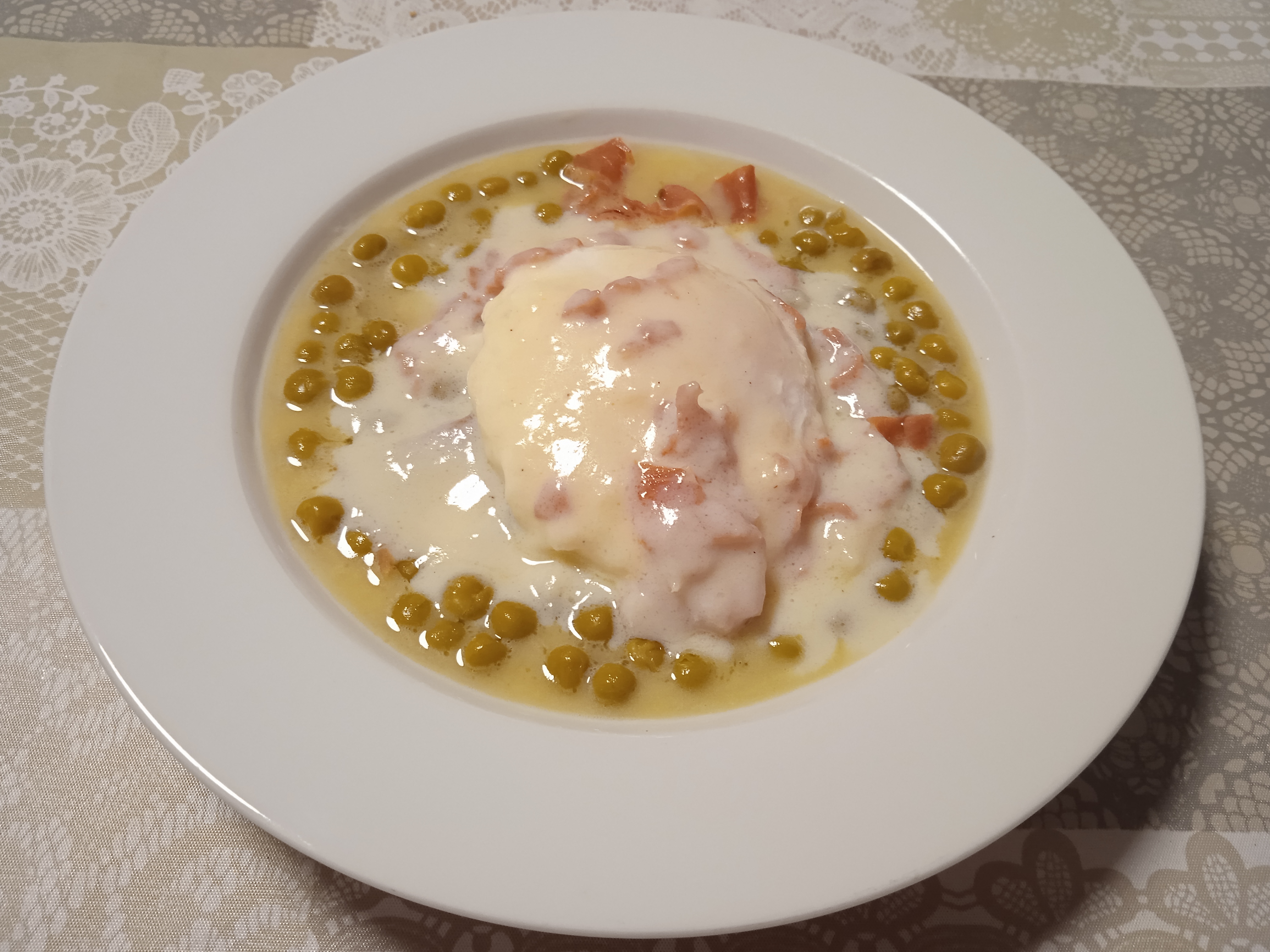 Guisantes salteados con jamón y huevo poché.